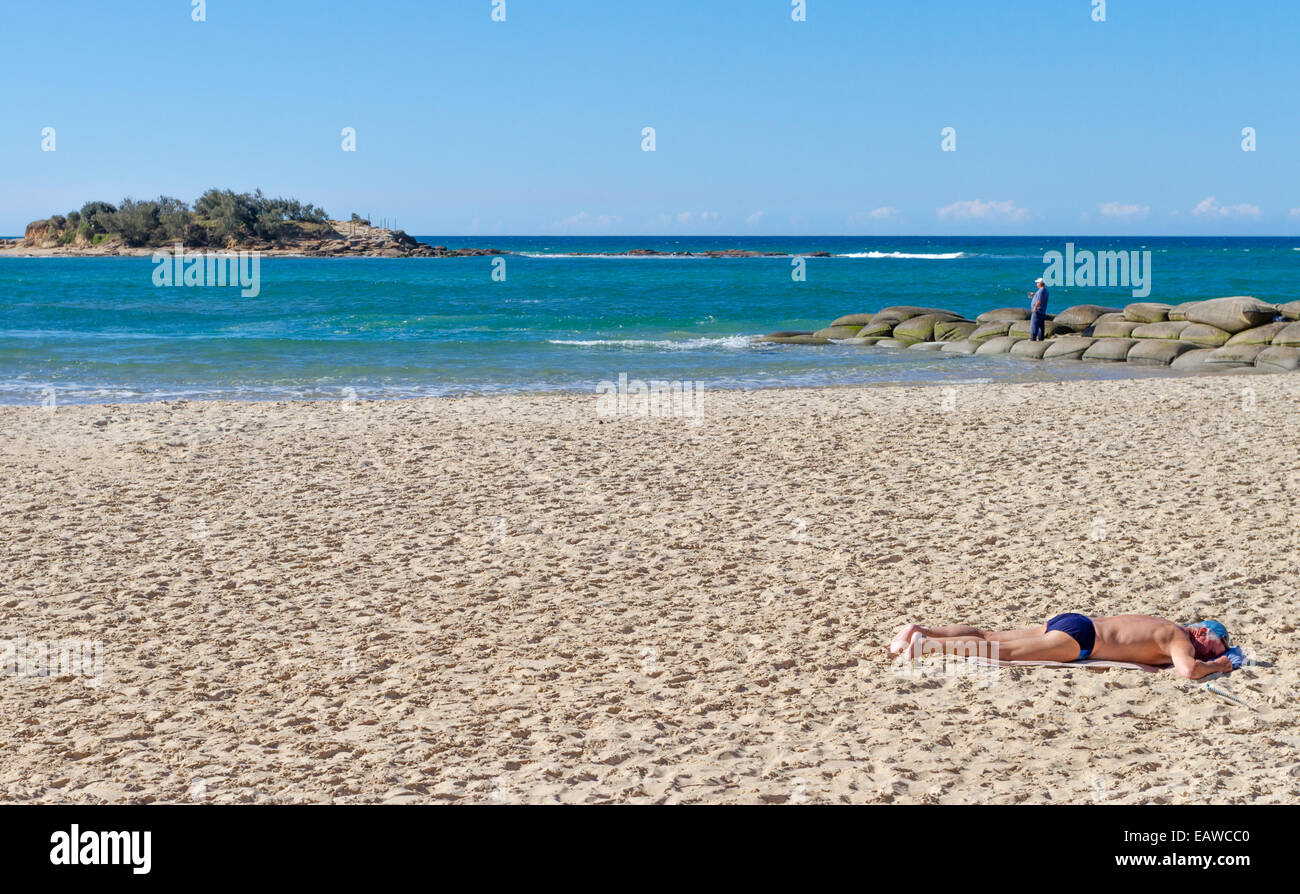 Sunbather on beach at mouth of Maroochy River, Sunshine Coast ...