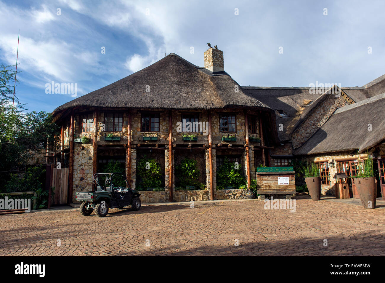 The thatched roof and handmade stone walls of an African safari lodge ...