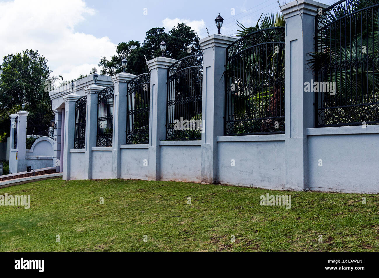 A high security fence and wall protects a home in an affluent suburb ...