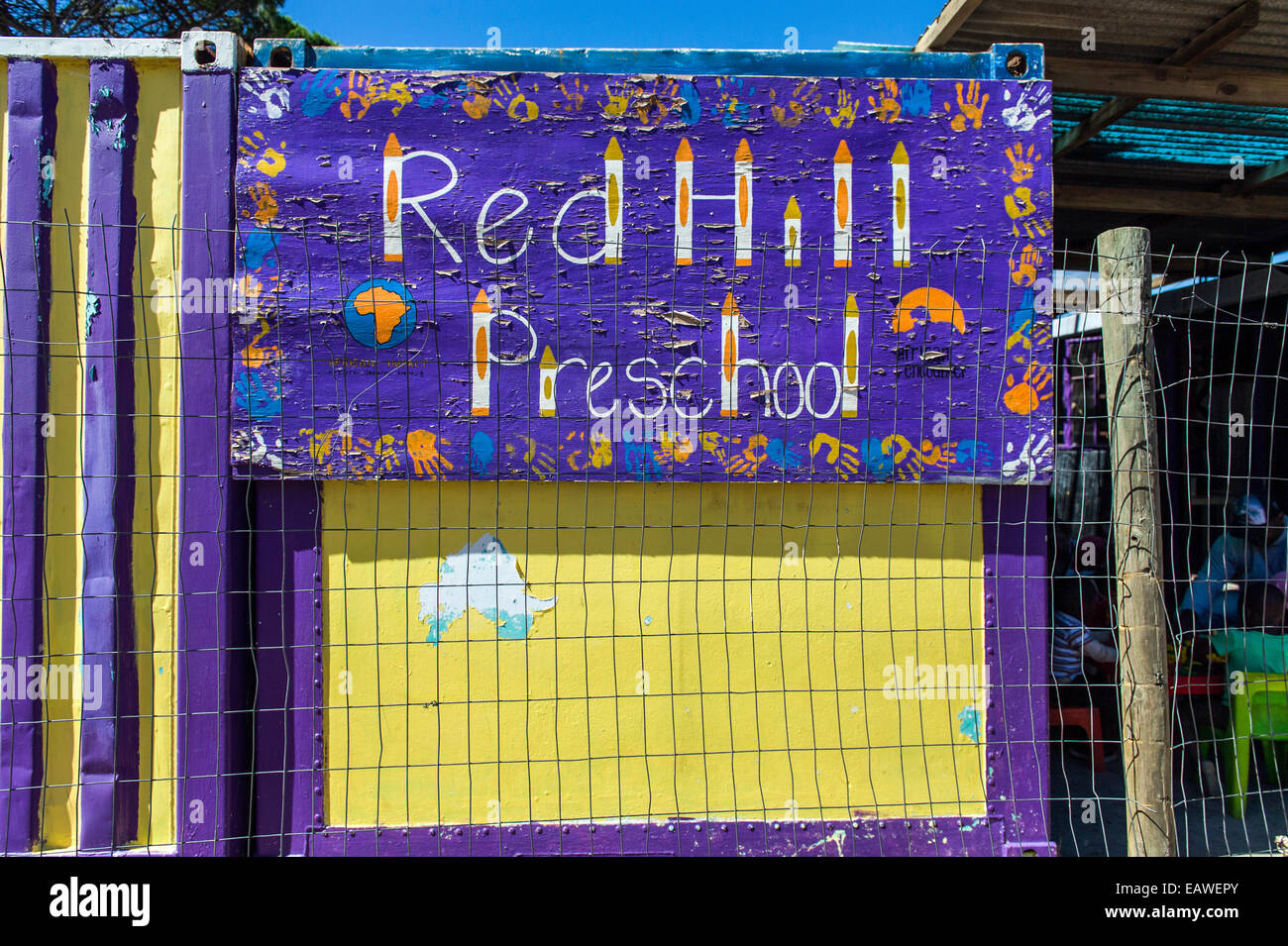 A bright purple and yellow Pre-school sign with childrens hand prints ...
