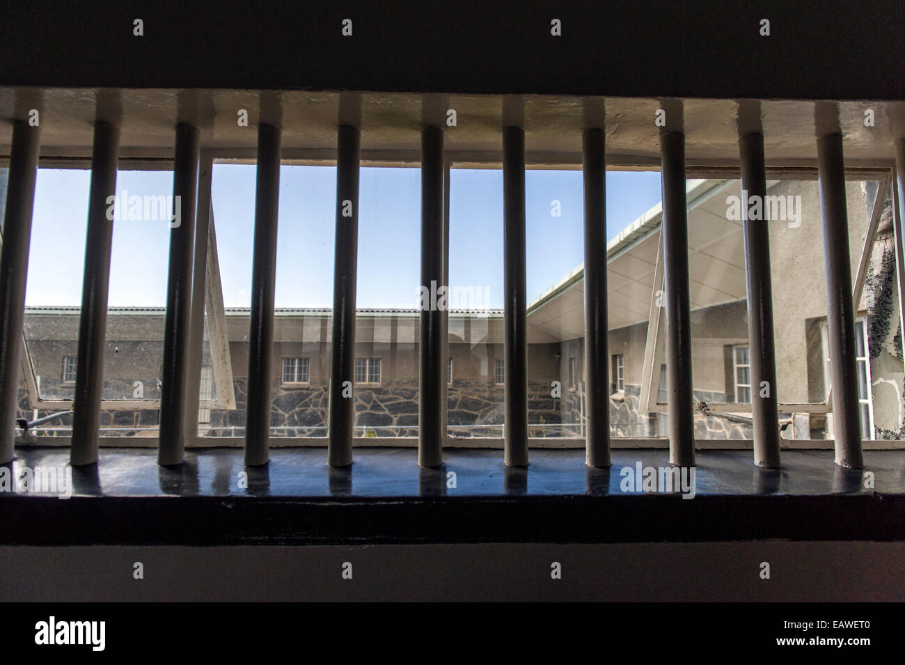 Looking through prison bars to an exercise yard and blue sky Stock ...