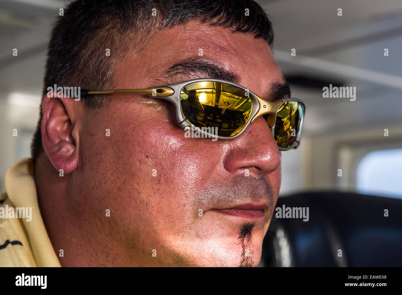 A ferry captain on the bridge guides his vessel across the open sea ...