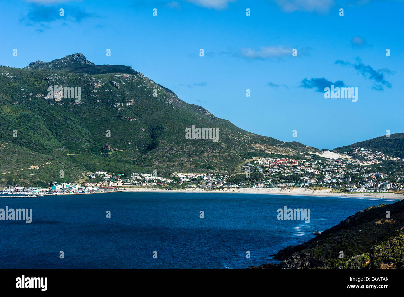 A coastal community nestled in a sheltered bay beneath mountain peaks ...