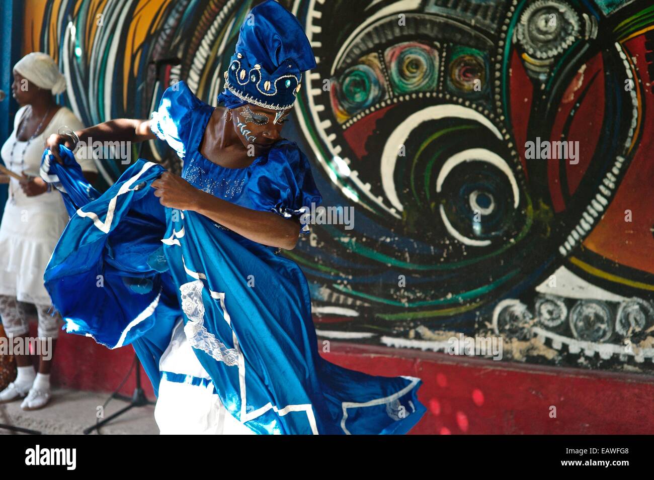 A woman dances the rumba in front of a brightly colored mural Stock ...