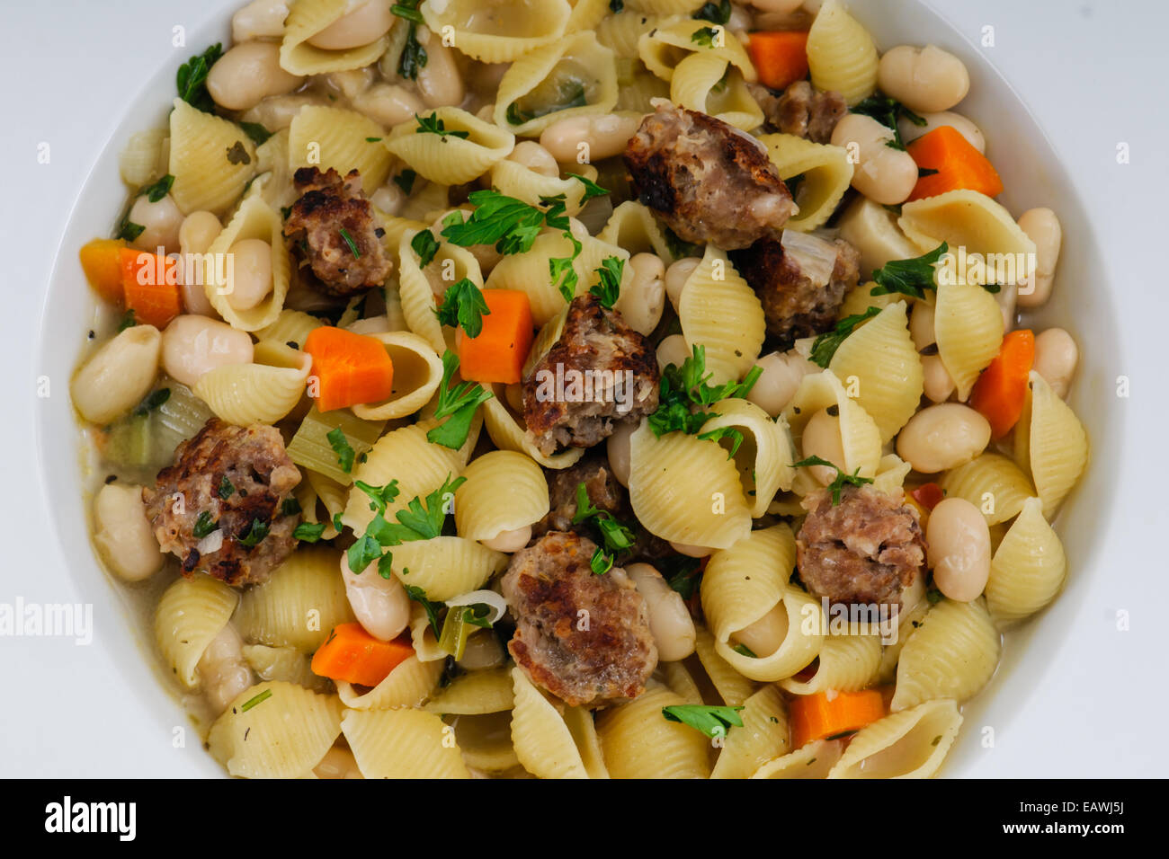 Hearty dinner of Italian sausage, white bean and shell pasta soup with ...