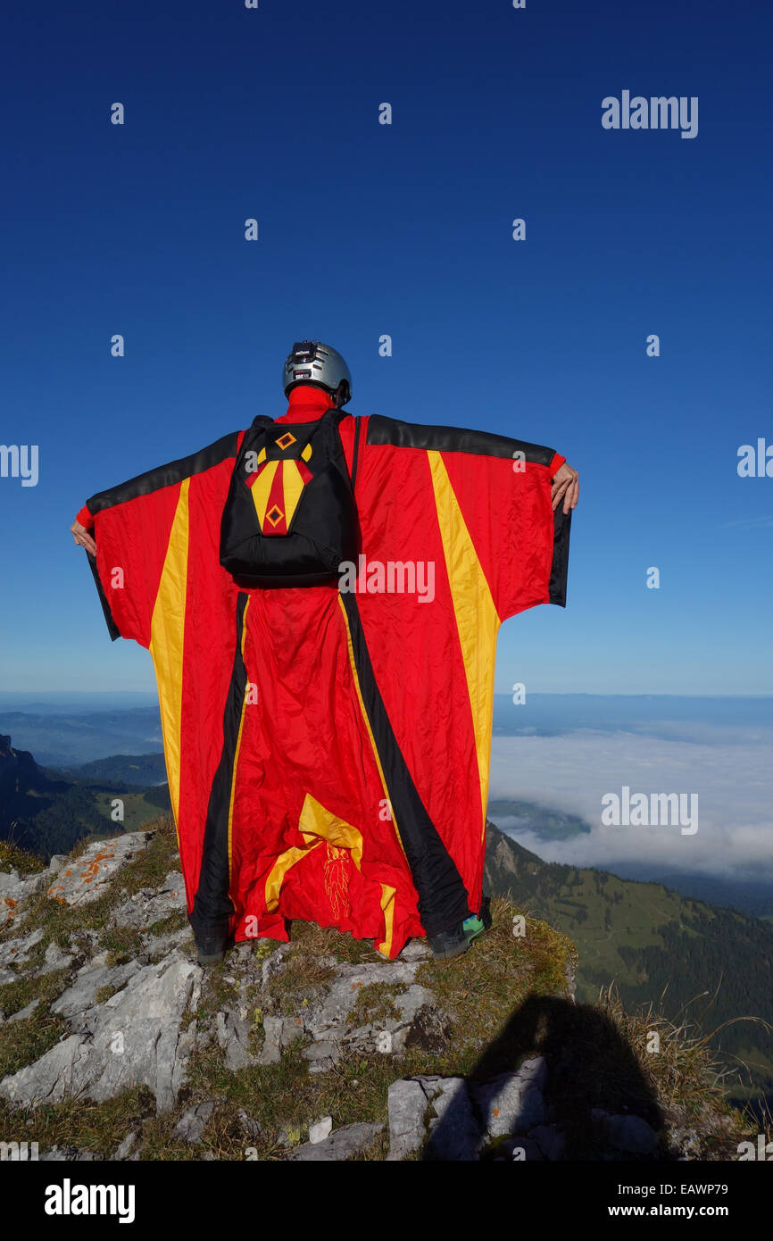 BASE jumper is exiting from a cliff down into the deep valley. Thereby ...