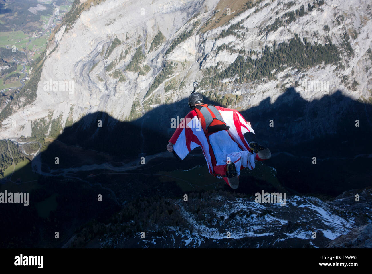 BASE jumper is exiting from a cliff down into the deep valley. Thereby ...