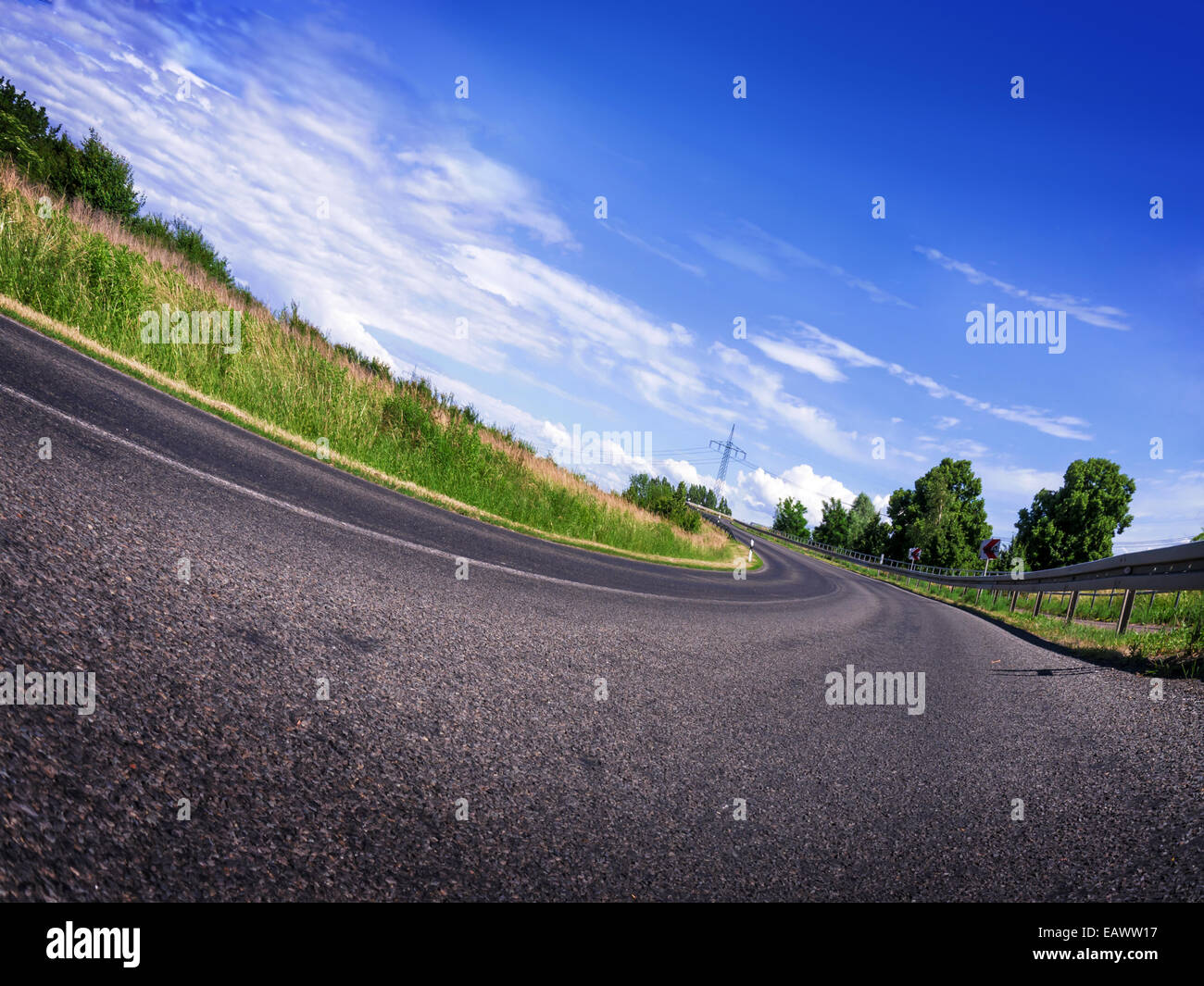 a curved road with blue sky in landscape Stock Photo - Alamy