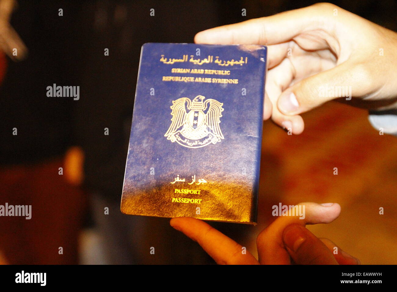 A refugee shows his Syrian passport. Syrian refugees who have fled from ...