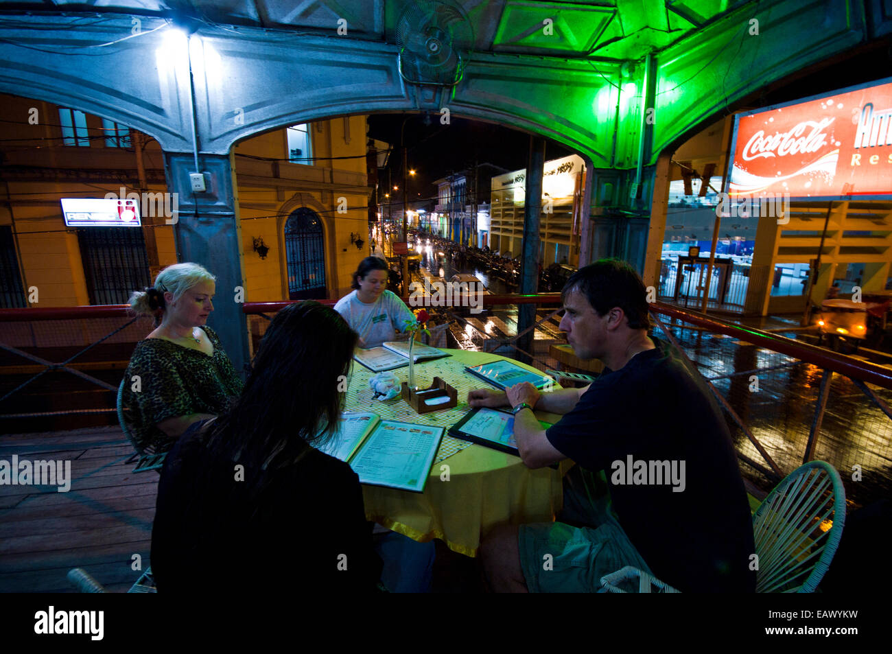 Tourists dine on the balcony of an antique steel restaurant in an ...