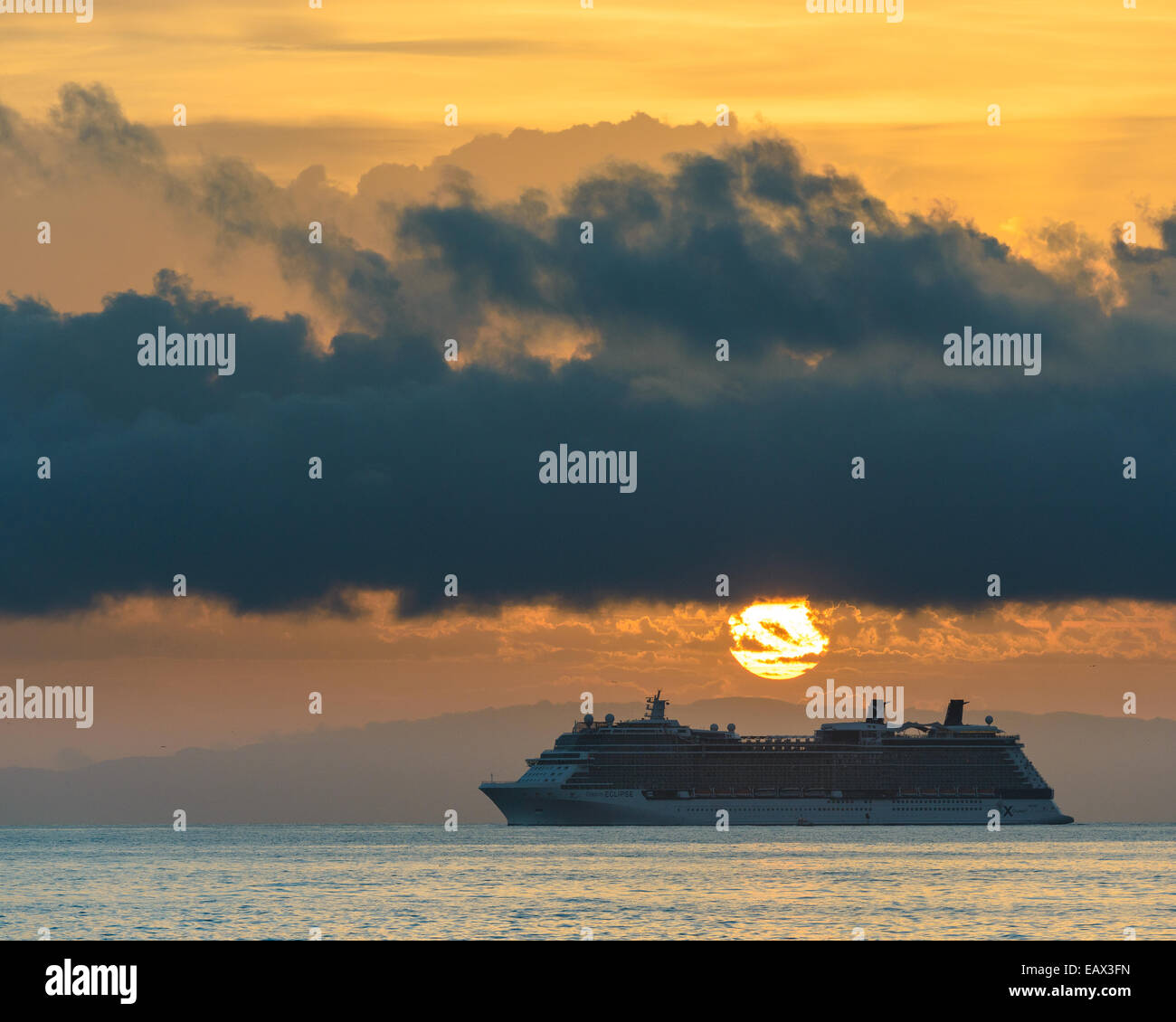 Cruise ship travels under the rising sun and dramatic clouds Stock ...