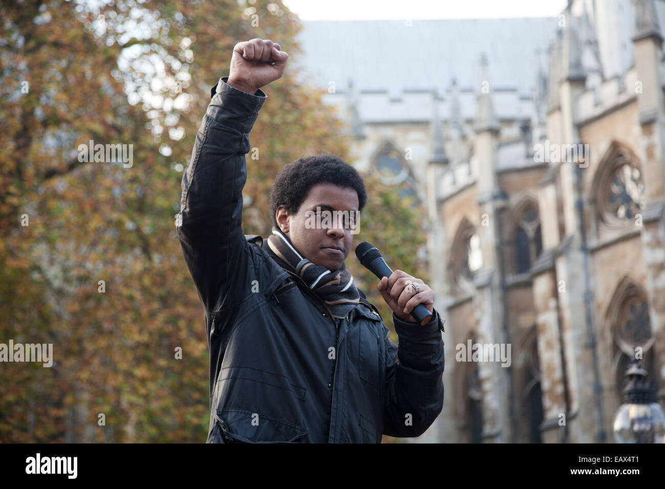 At the rally outside Parliament a speaker holds his fist up calling for ...
