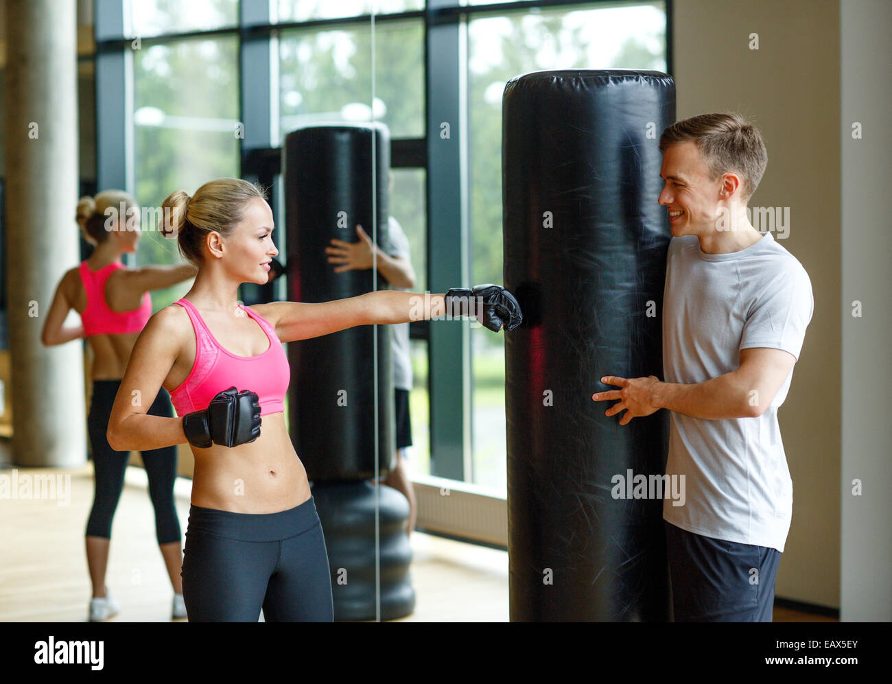 smiling woman with personal trainer boxing in gym Stock Photo - Alamy
