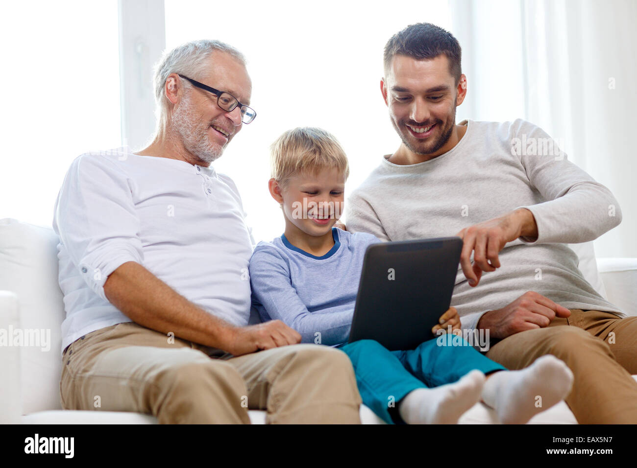 smiling family with tablet pc at home Stock Photo - Alamy
