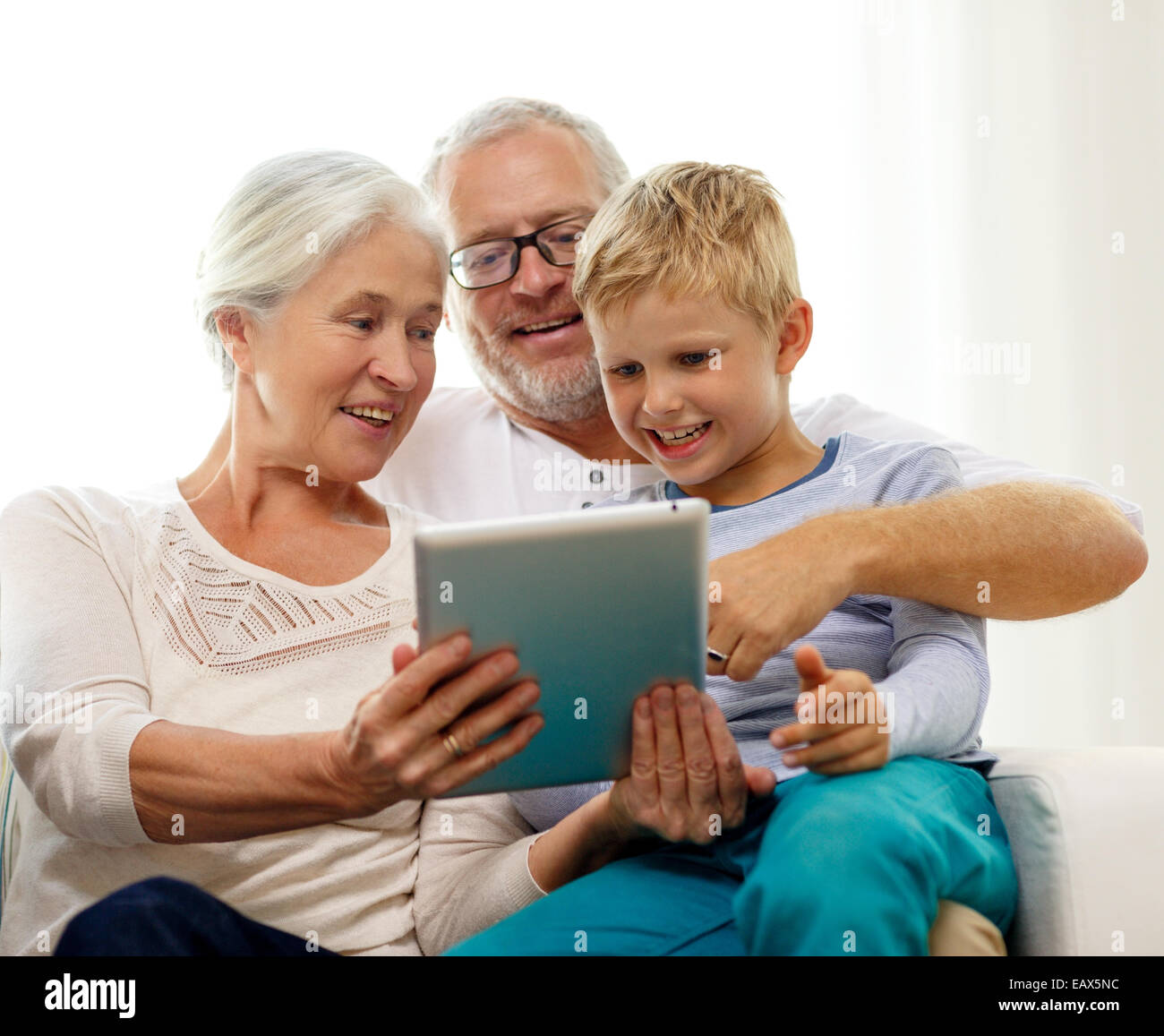 smiling family with tablet pc at home Stock Photo - Alamy