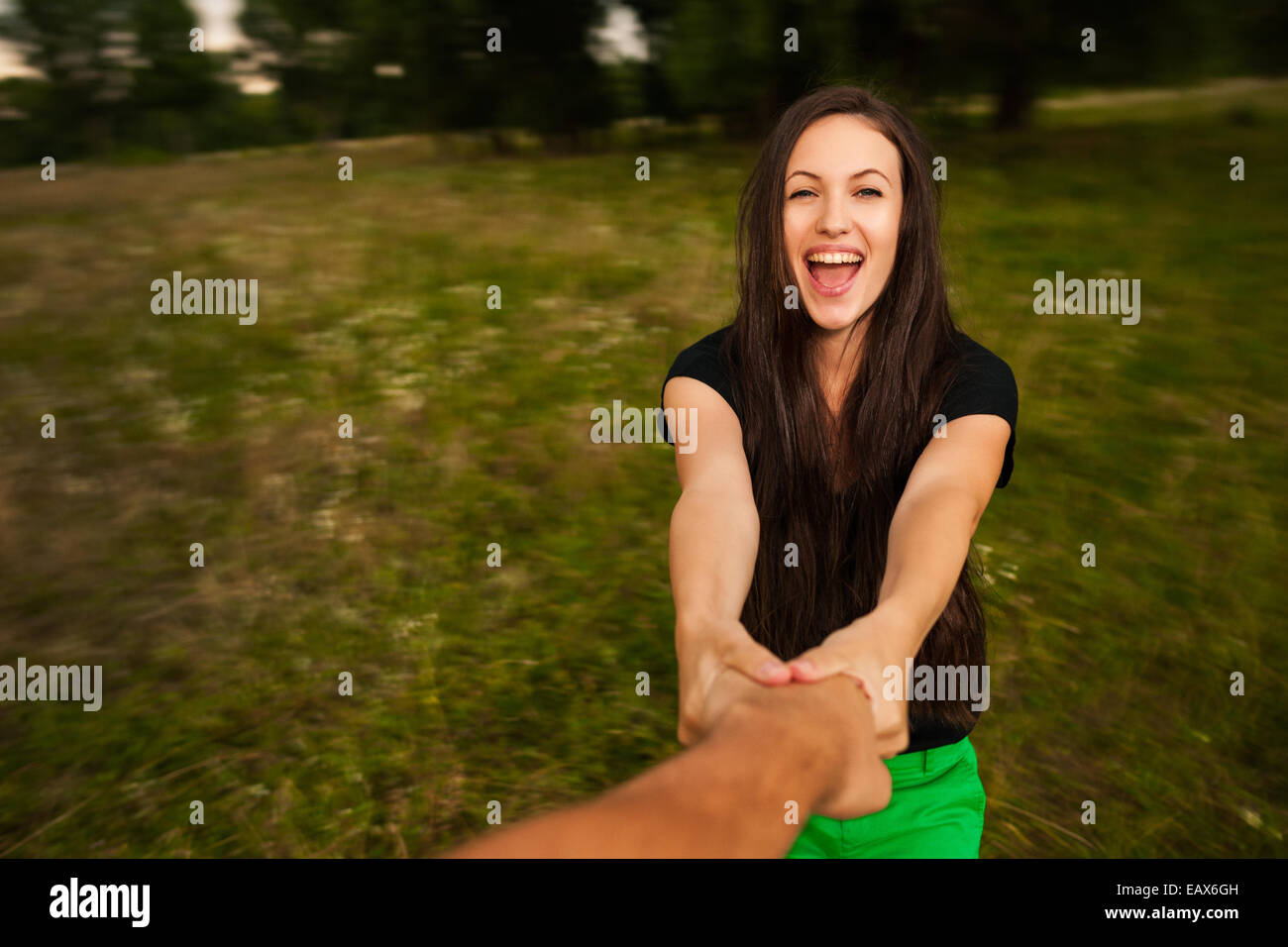 Young happy woman spinning around holding man's hand Stock Photo - Alamy
