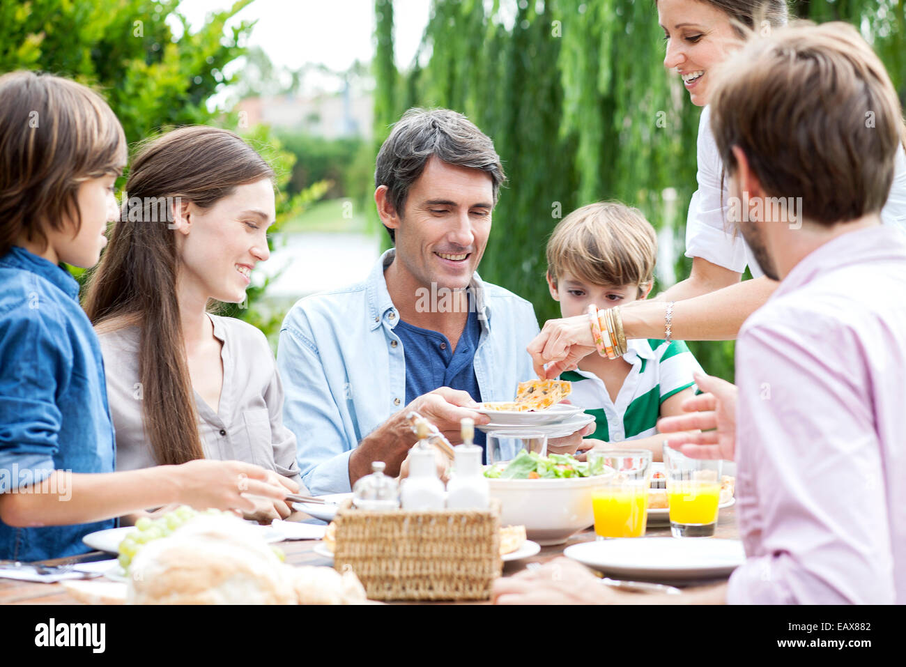 Family eating together at outdoor gathering Stock Photo - Alamy