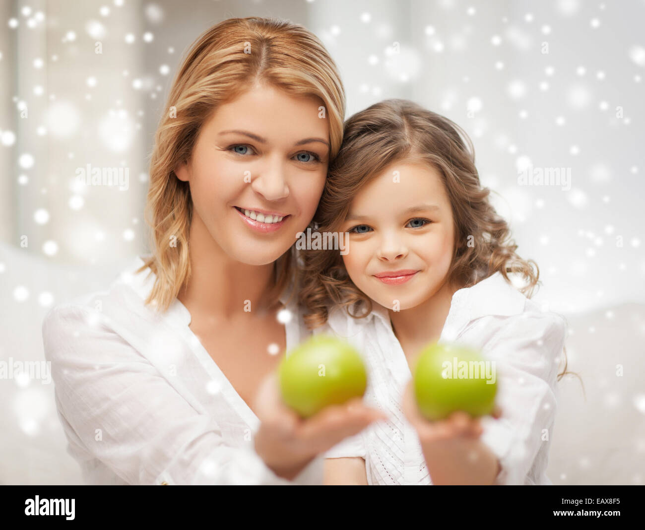 happy mother and daughter holding green apples Stock Photo - Alamy