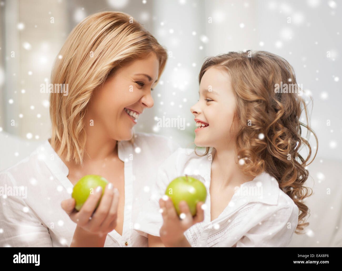 happy mother and daughter holding green apples Stock Photo - Alamy