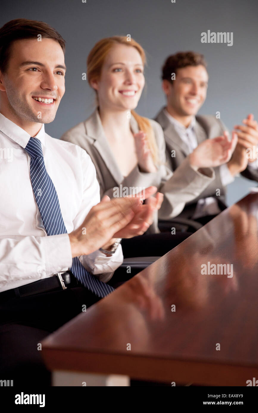 Young business professionals applauding at conclusion of presentation ...