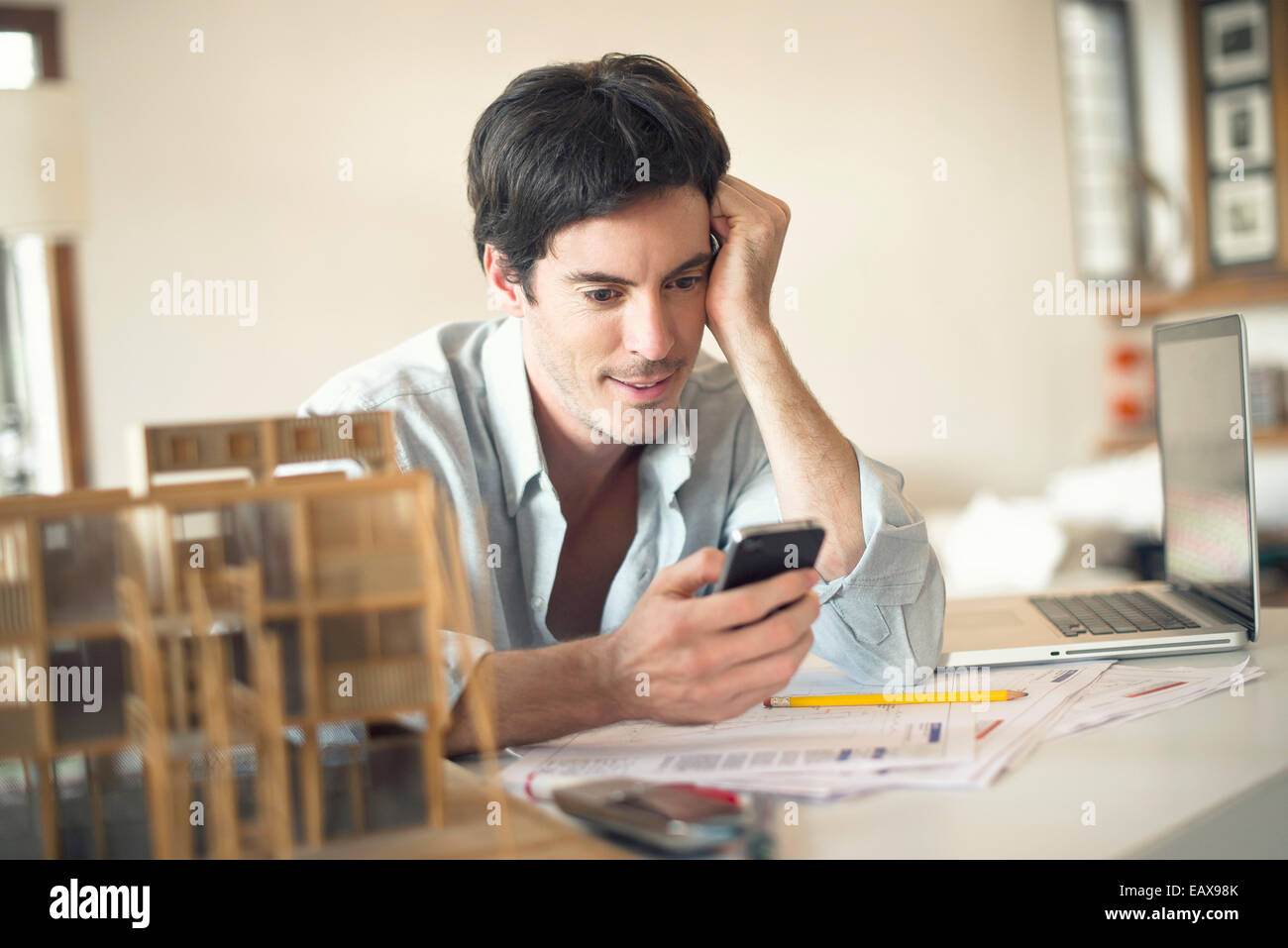 Businessman using cell phone at desk Stock Photo - Alamy