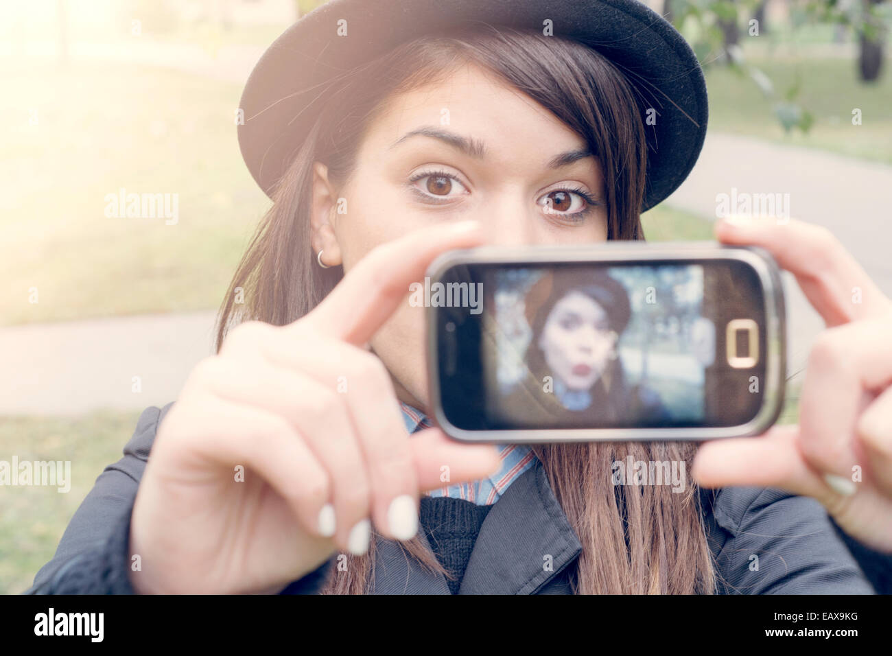 Beautiful young woman photographing herself with phone.,selective focus ...