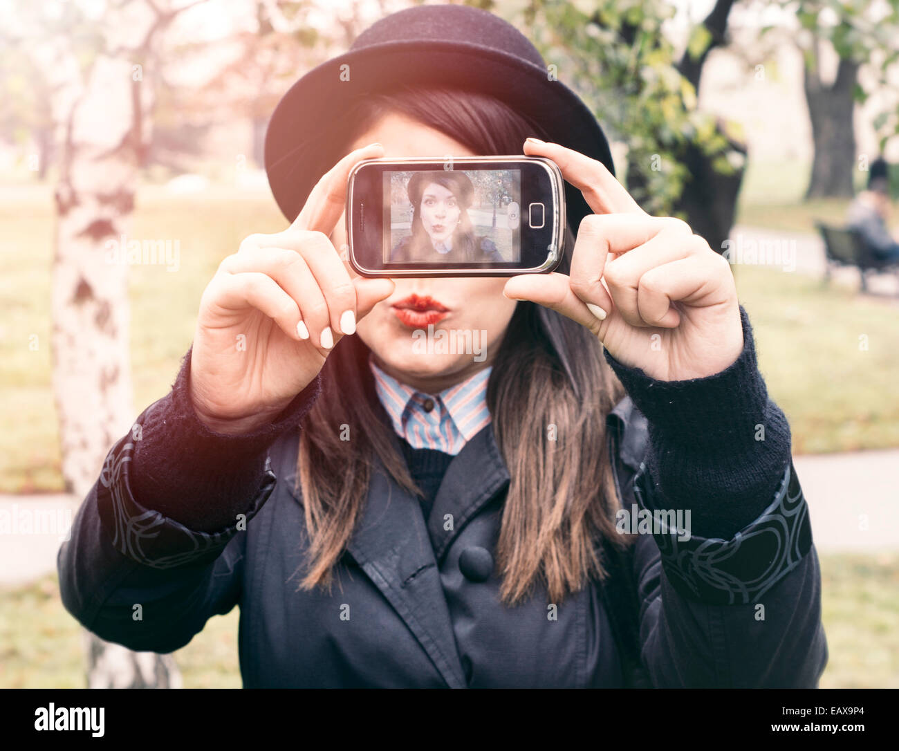 Beautiful young woman photographing herself with phone,selective focus ...