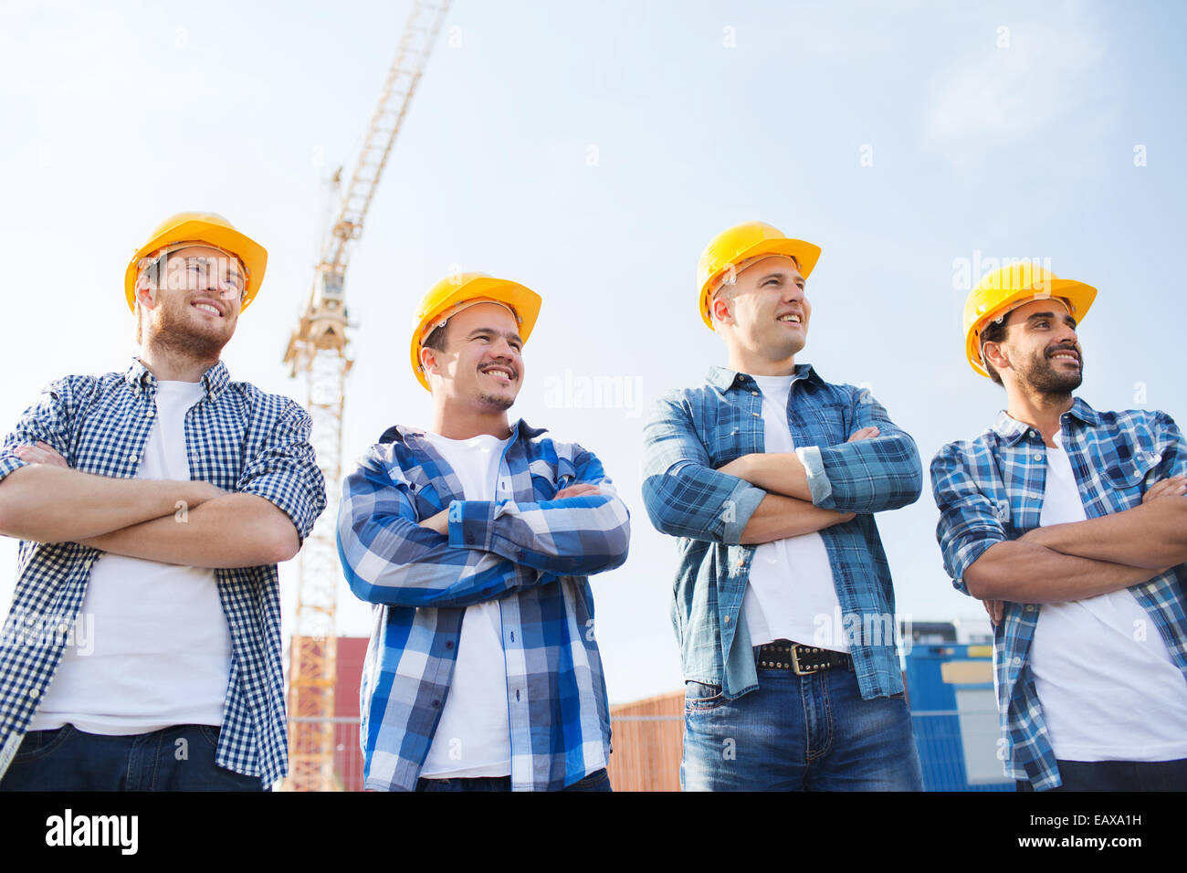 group of smiling builders in hardhats outdoors Stock Photo - Alamy
