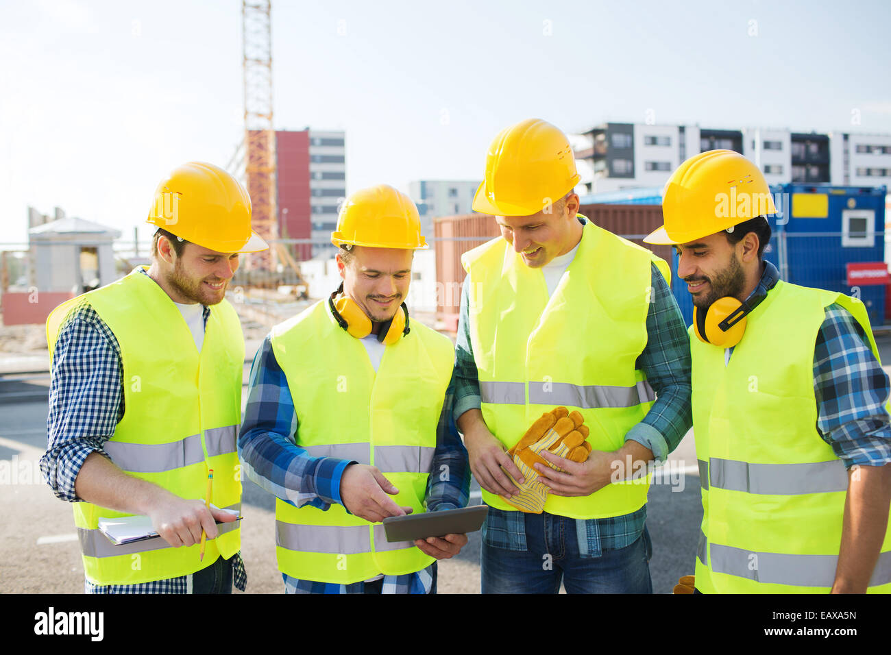 group of smiling builders with tablet pc outdoors Stock Photo - Alamy