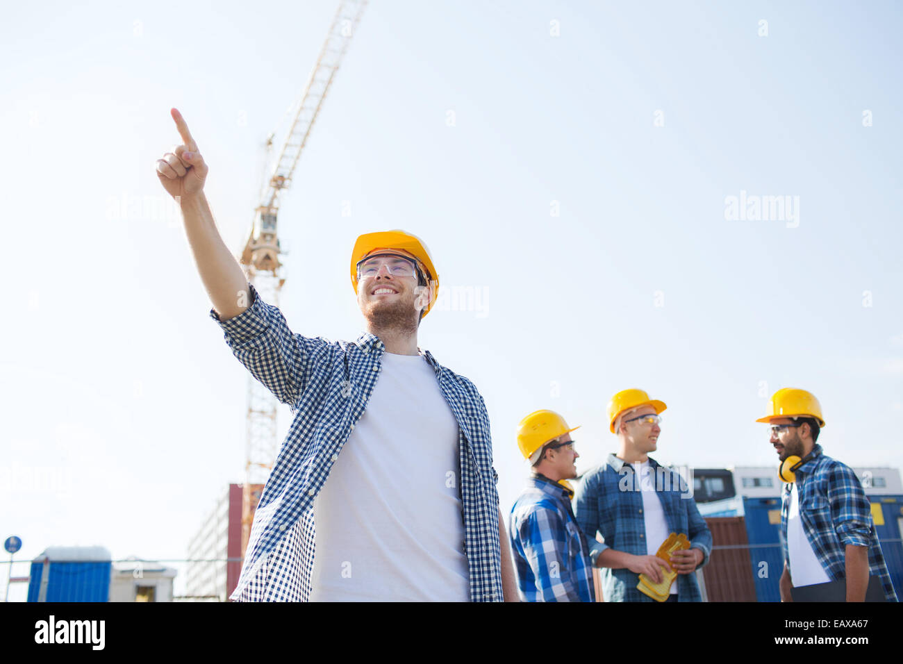 group of smiling builders in hardhats outdoors Stock Photo - Alamy