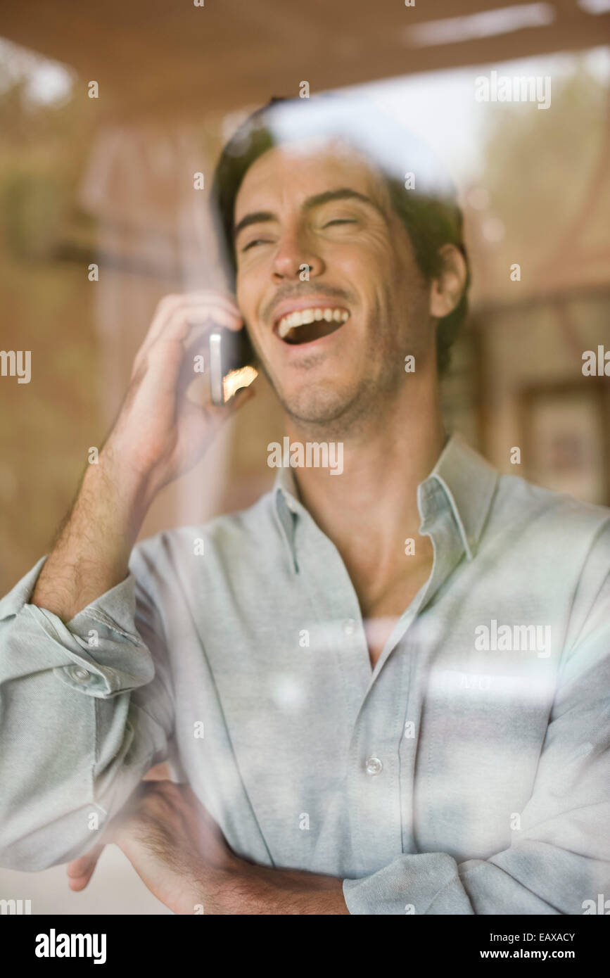 Man using cell phone bursting out laughing Stock Photo - Alamy