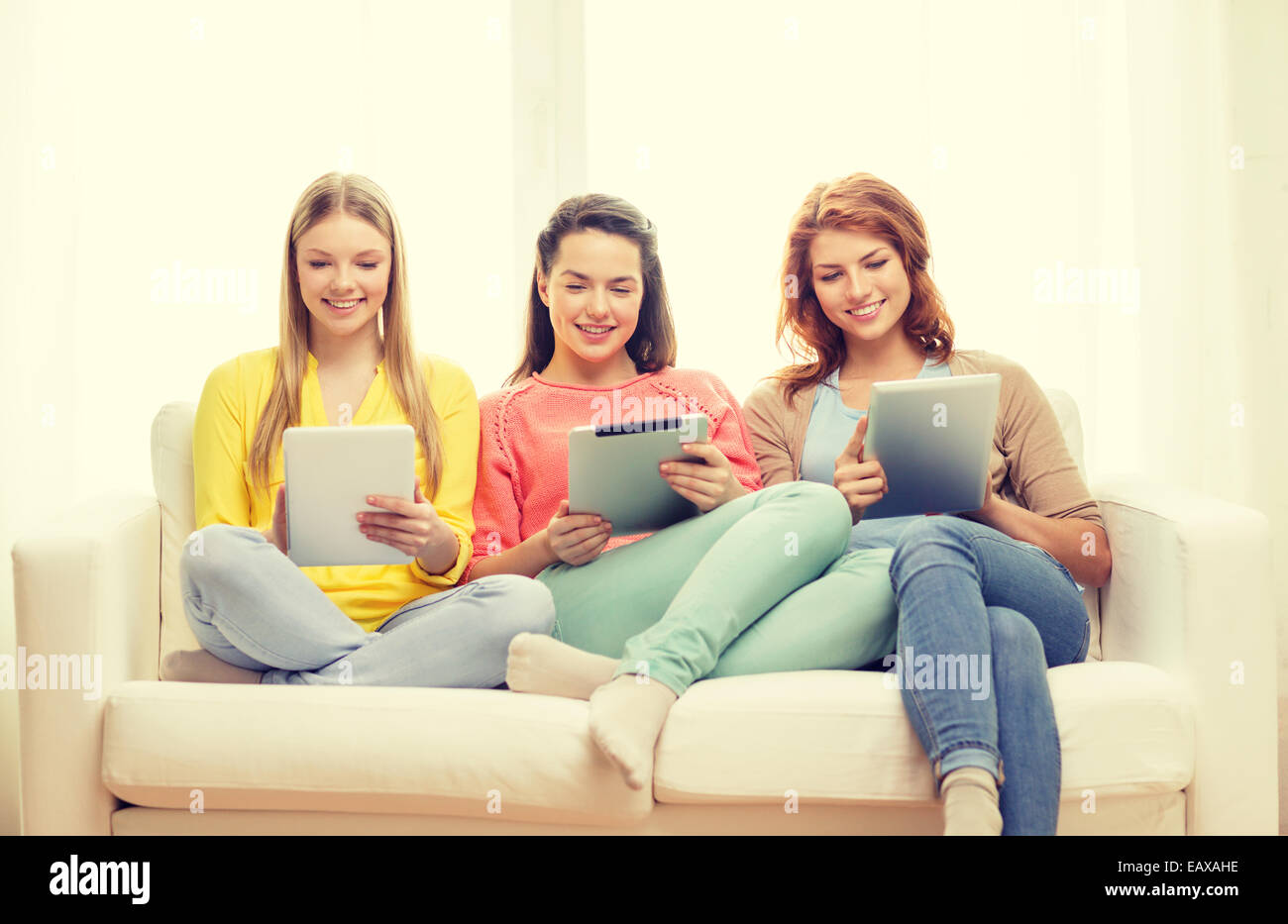 three smiling teenage girls with tablet pc at home Stock Photo - Alamy