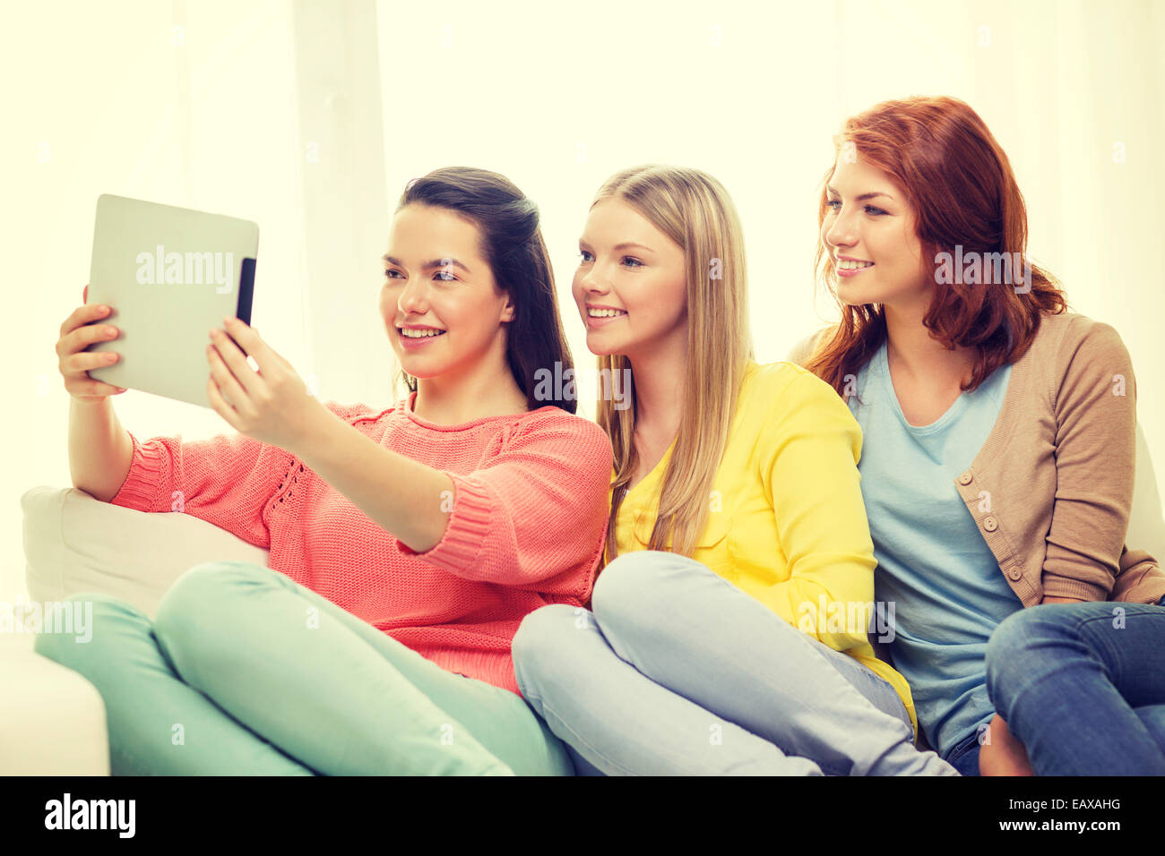 three smiling teenage girls with tablet pc at home Stock Photo - Alamy