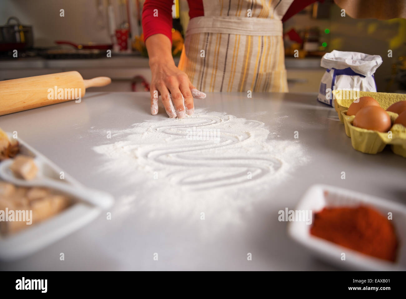 Closeup on young housewife drawing with flour on table Stock Photo - Alamy