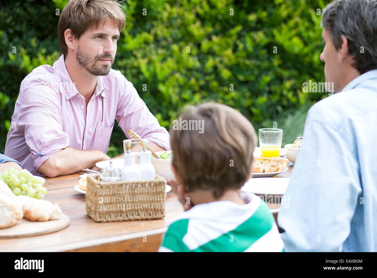 Men chatting at outdoor family gathering Stock Photo - Alamy