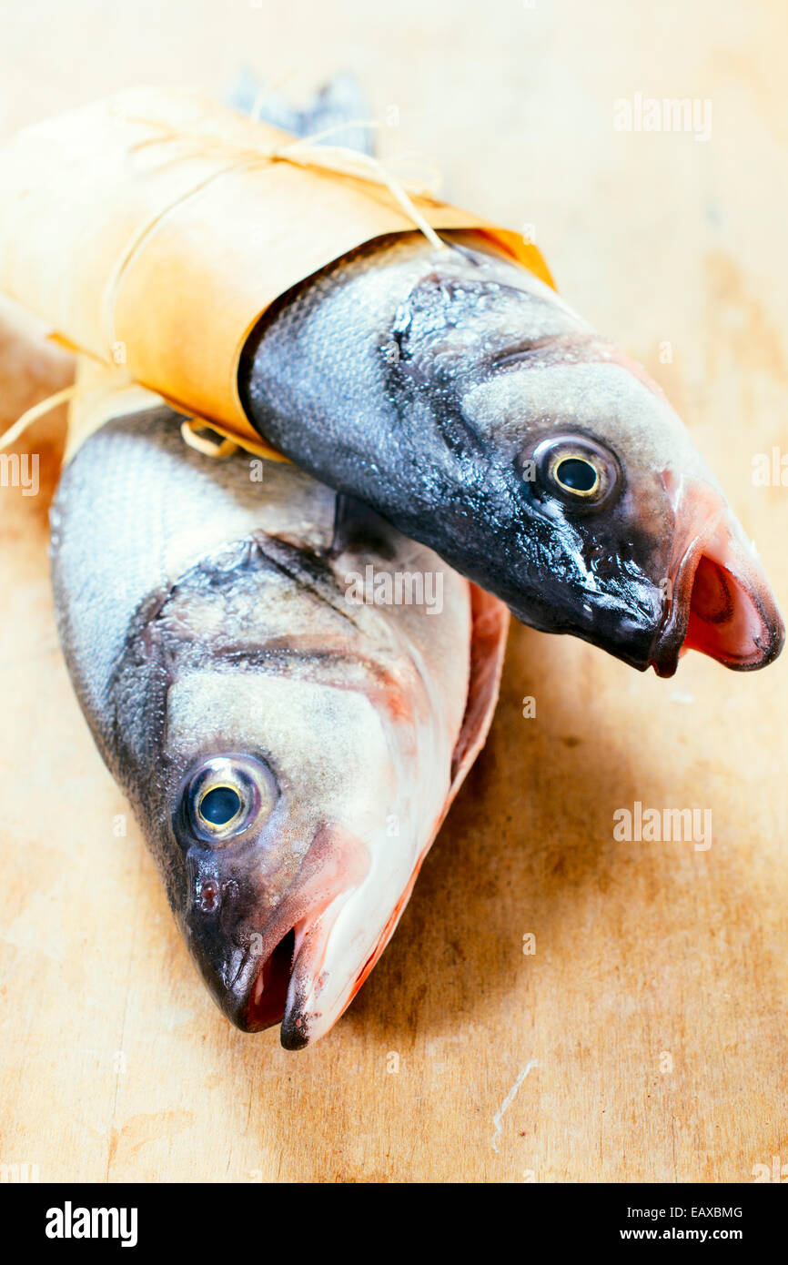Couple of raw bass fish on the wooden background,selective focus Stock ...