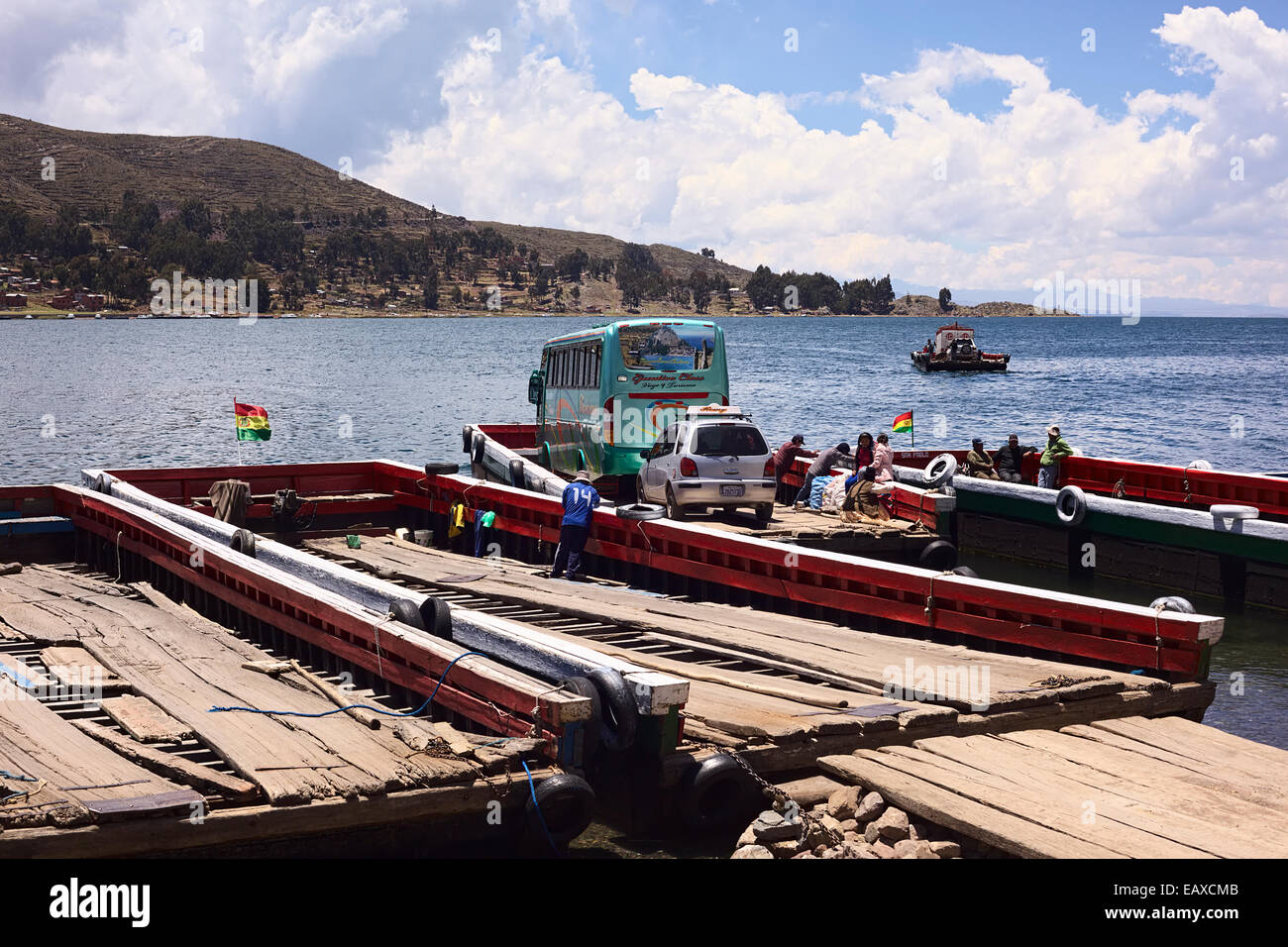 Wooden ferry loaded with bus and car leaving the shore of Lake Titicaca ...