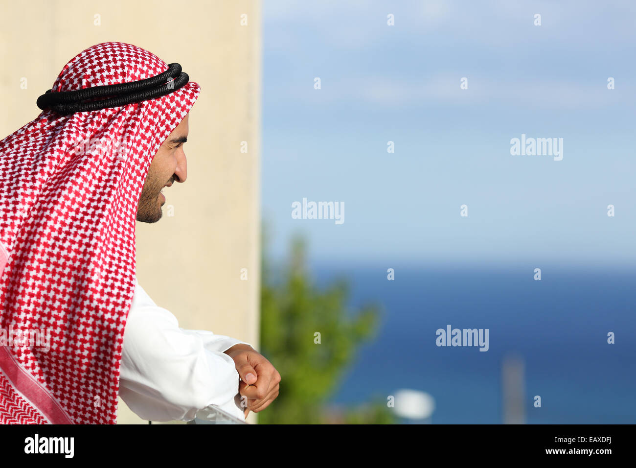 Happy relaxed arab saudi man looking the sea from a balcony of an hotel ...