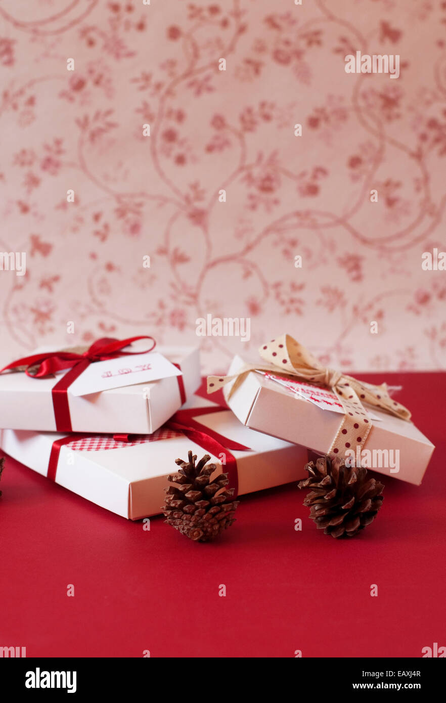 Still life concept image of white boxes gift wrapped with a pine cone ...