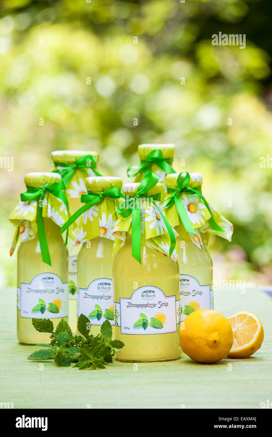 Bottles with lemon balm syrup in the garden Stock Photo - Alamy