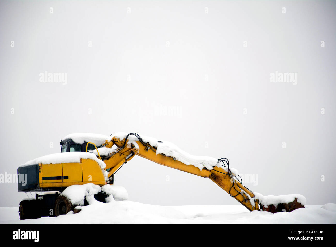 Excavator being covered with a snow in winter Stock Photo - Alamy