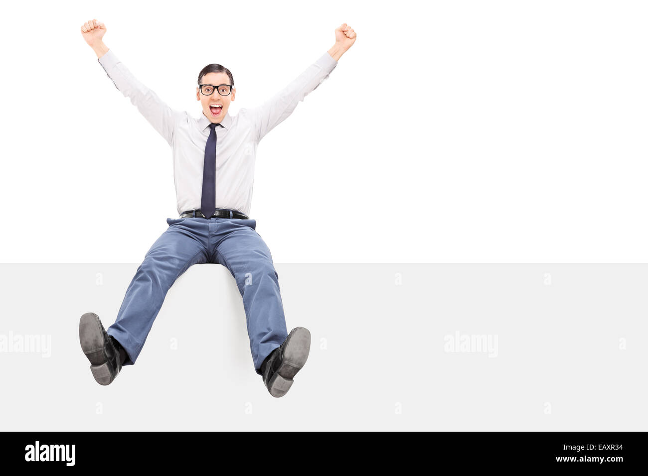 Happy guy sitting on a panel and throwing his hand in the air isolated ...