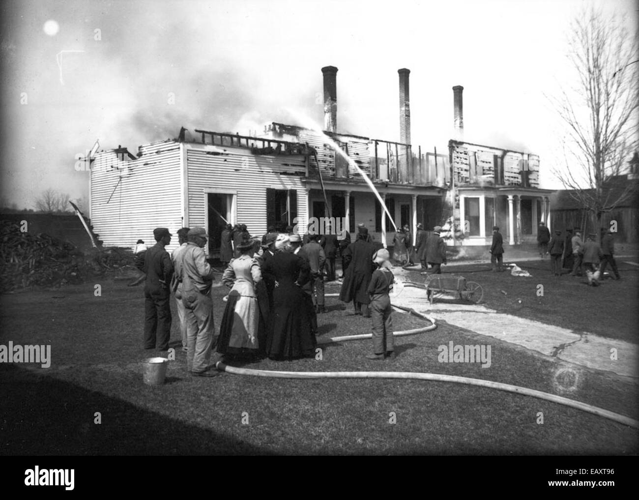 This photograph shows the aftermath of a fire at a three-chimneyed ...