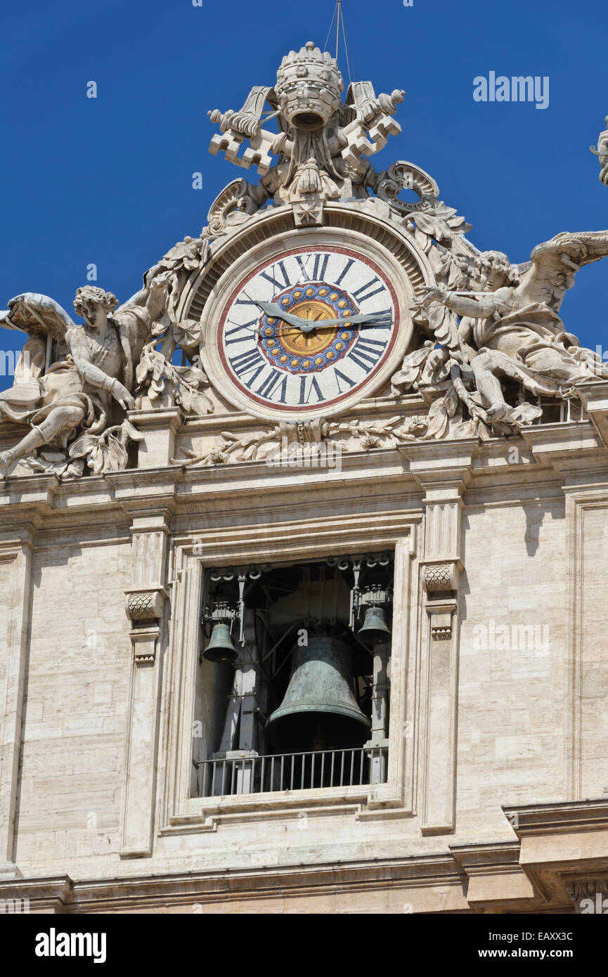 An ornate clock on the top facade of St Peter Basilica in Vatican City ...