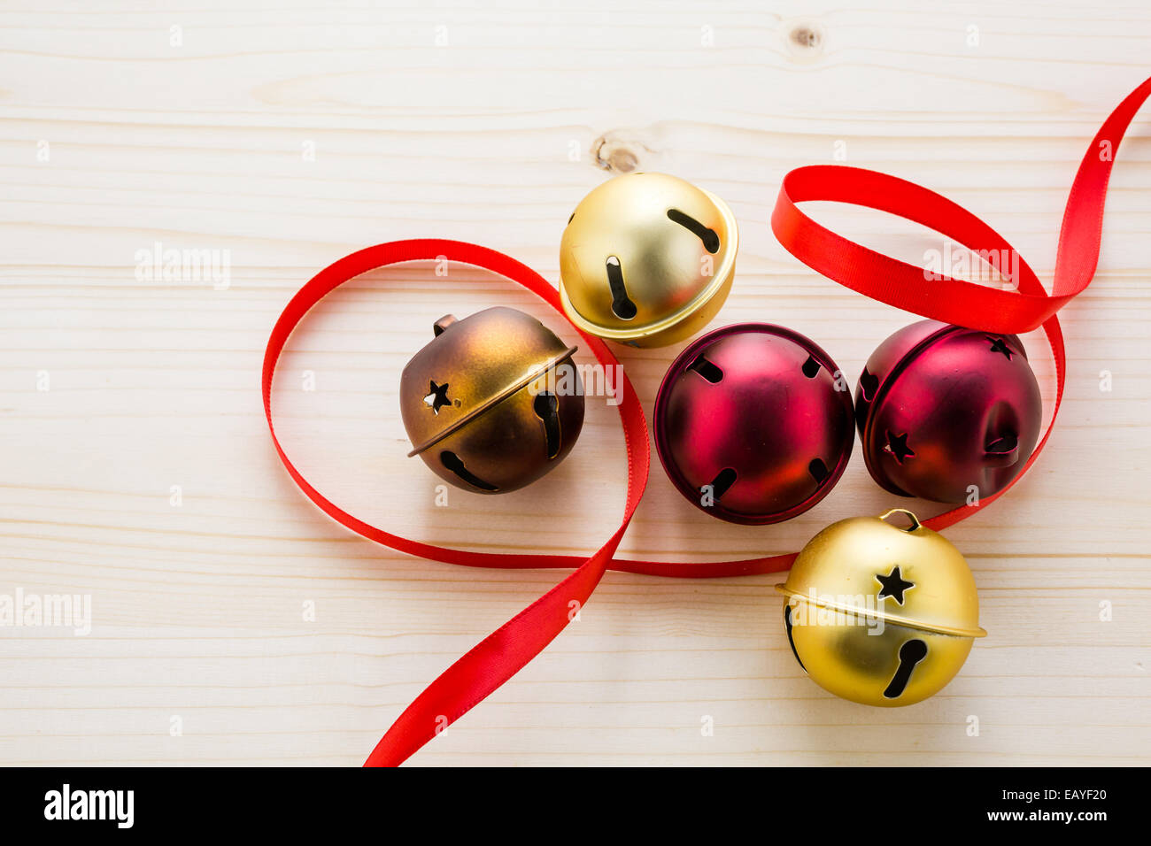 Multicolor jingle bells with red ribbon Stock Photo - Alamy