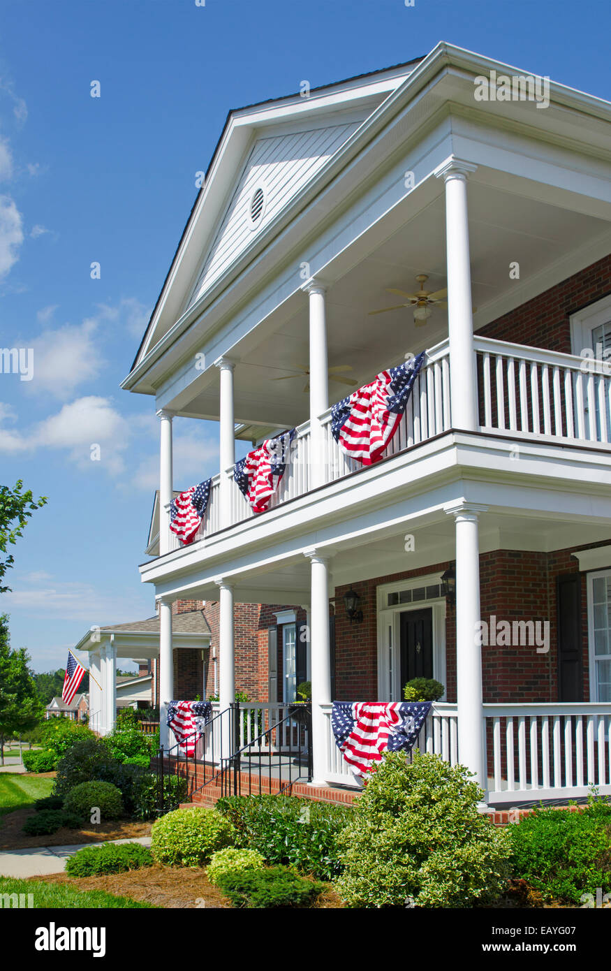 Buntings hang from a front porch of an upscale, brick home in ...