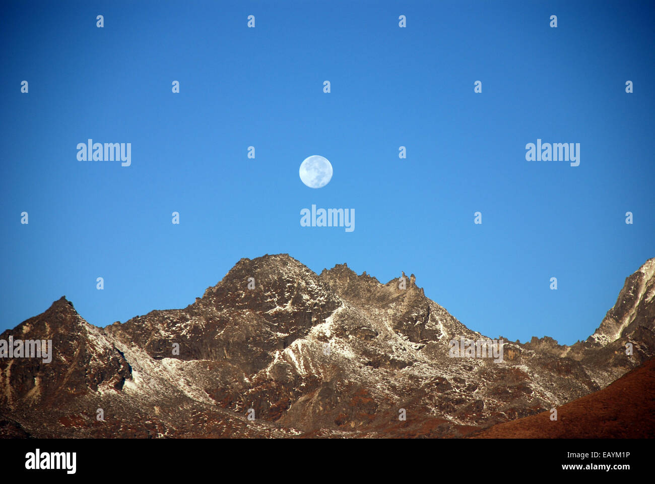 The moon rises above the Himalayan foothills in the Indian state of ...