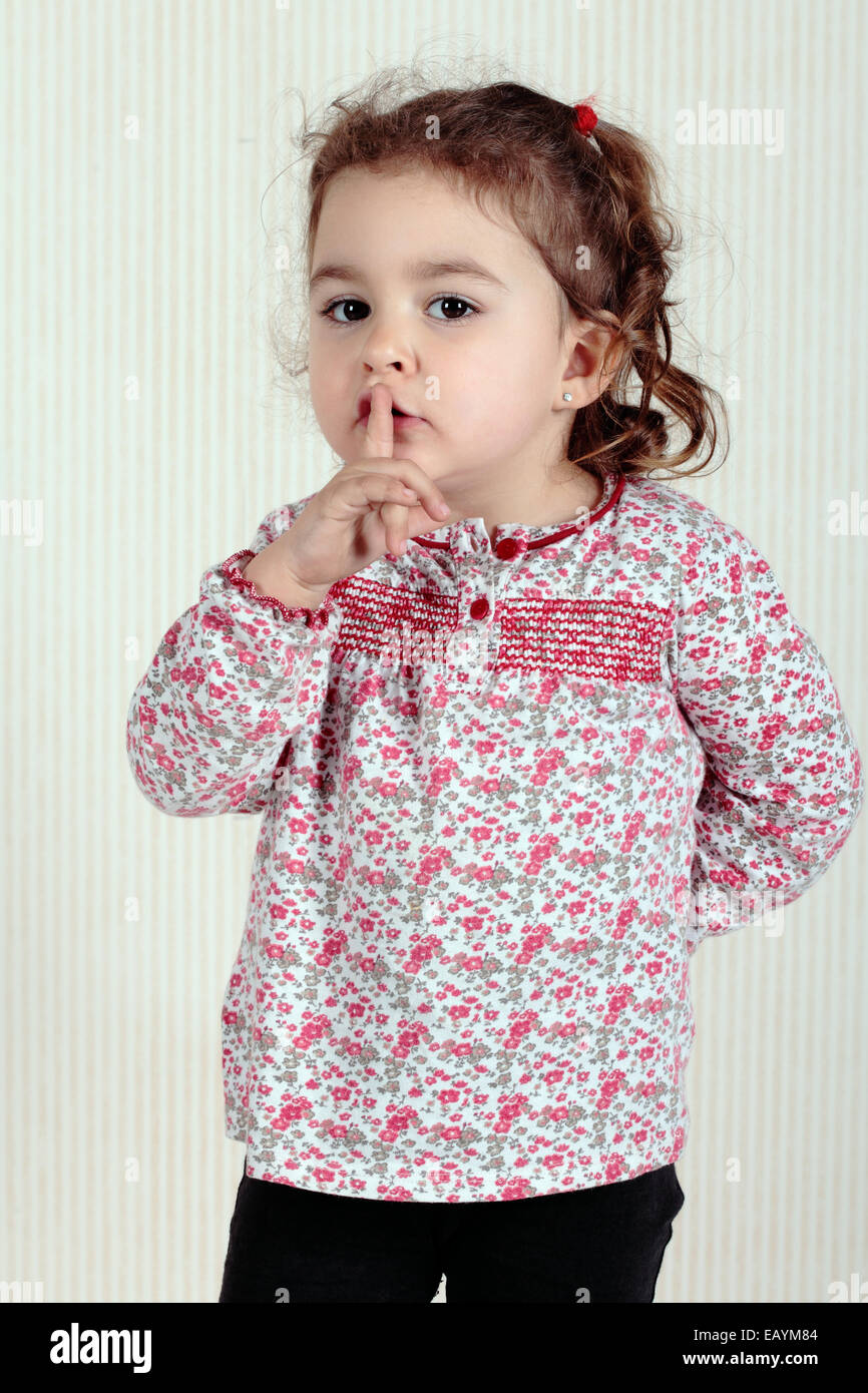a pretty little girl making silence sign Stock Photo - Alamy