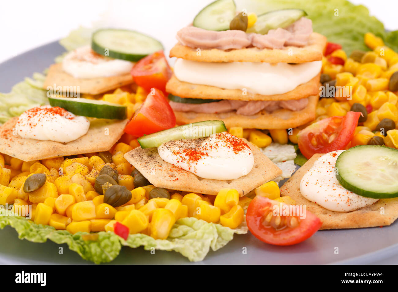 Fish cream on crackers, sweet corn, cherry tomato and lettuce closeup ...