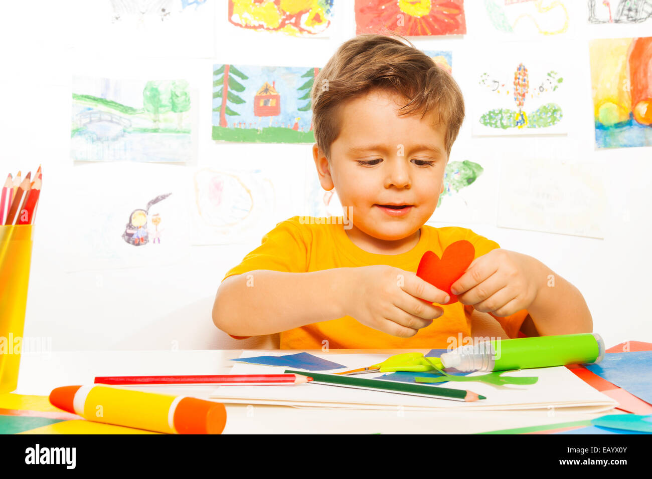 Happy small boy crafting heart shaped carton Stock Photo - Alamy